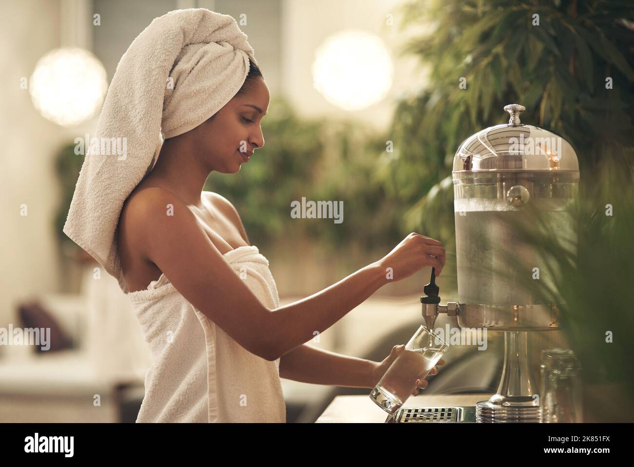 That massage left me quite thirsty. a woman filling her glass at a ...