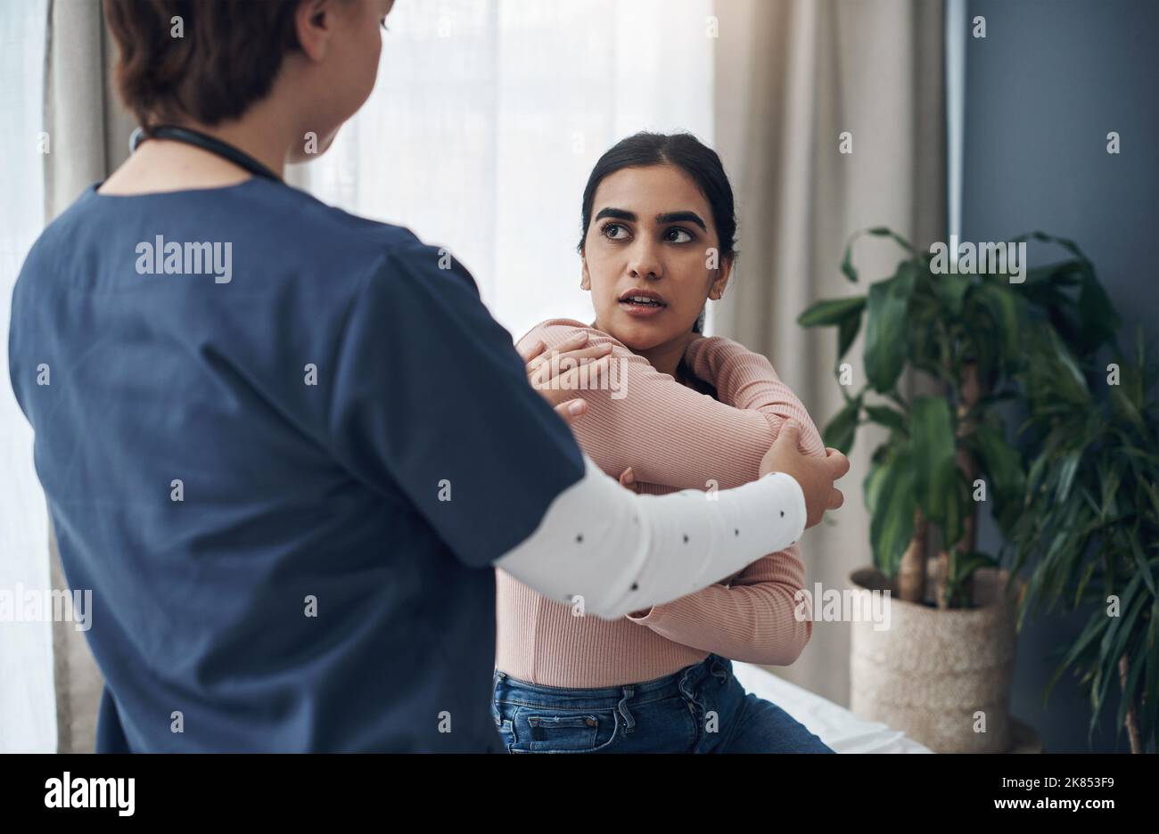 Lets see if you can move it all the way. a young female doctor checking ...