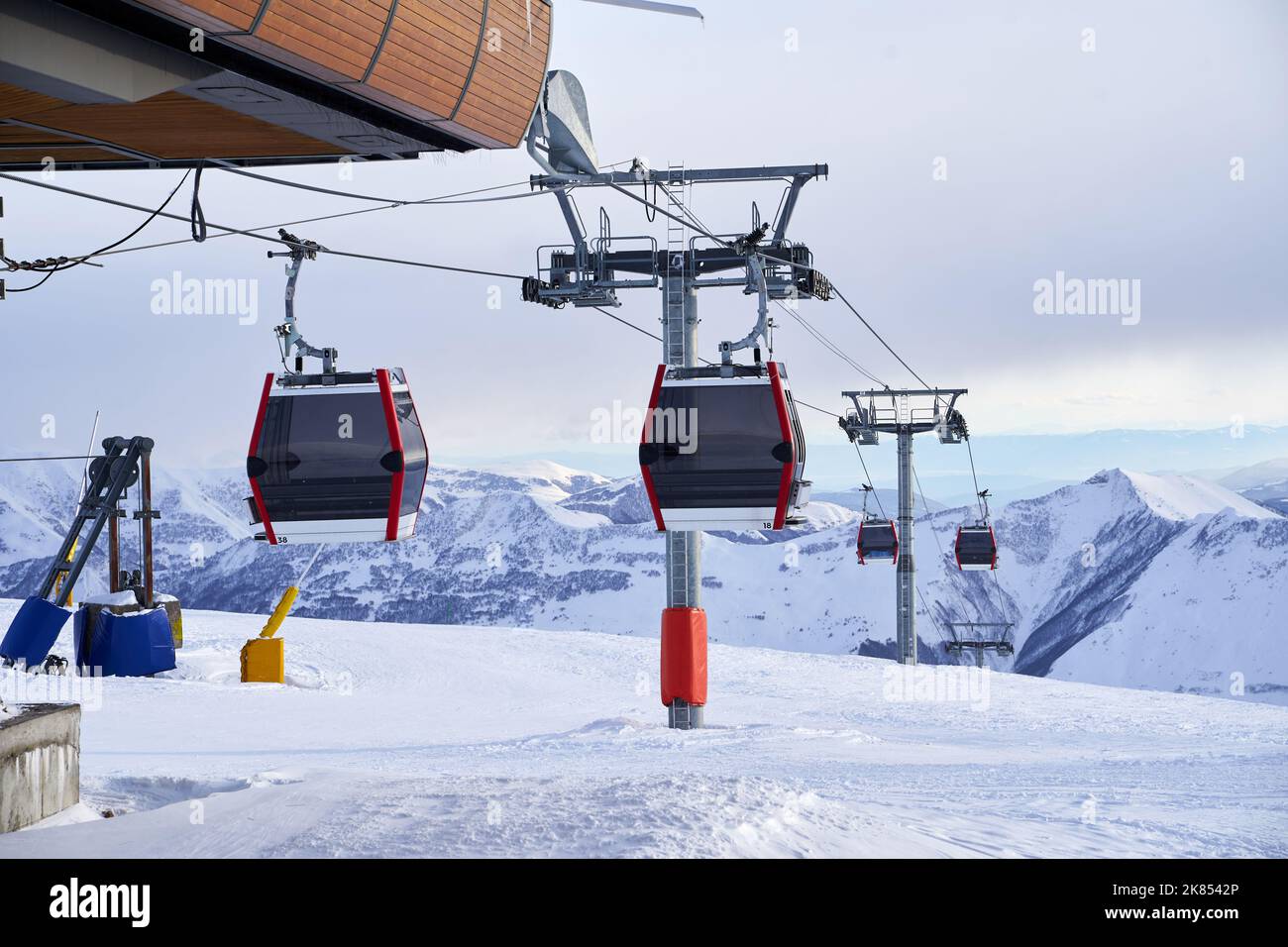Cable car gondola at ski resort with snowy mountains on background ...