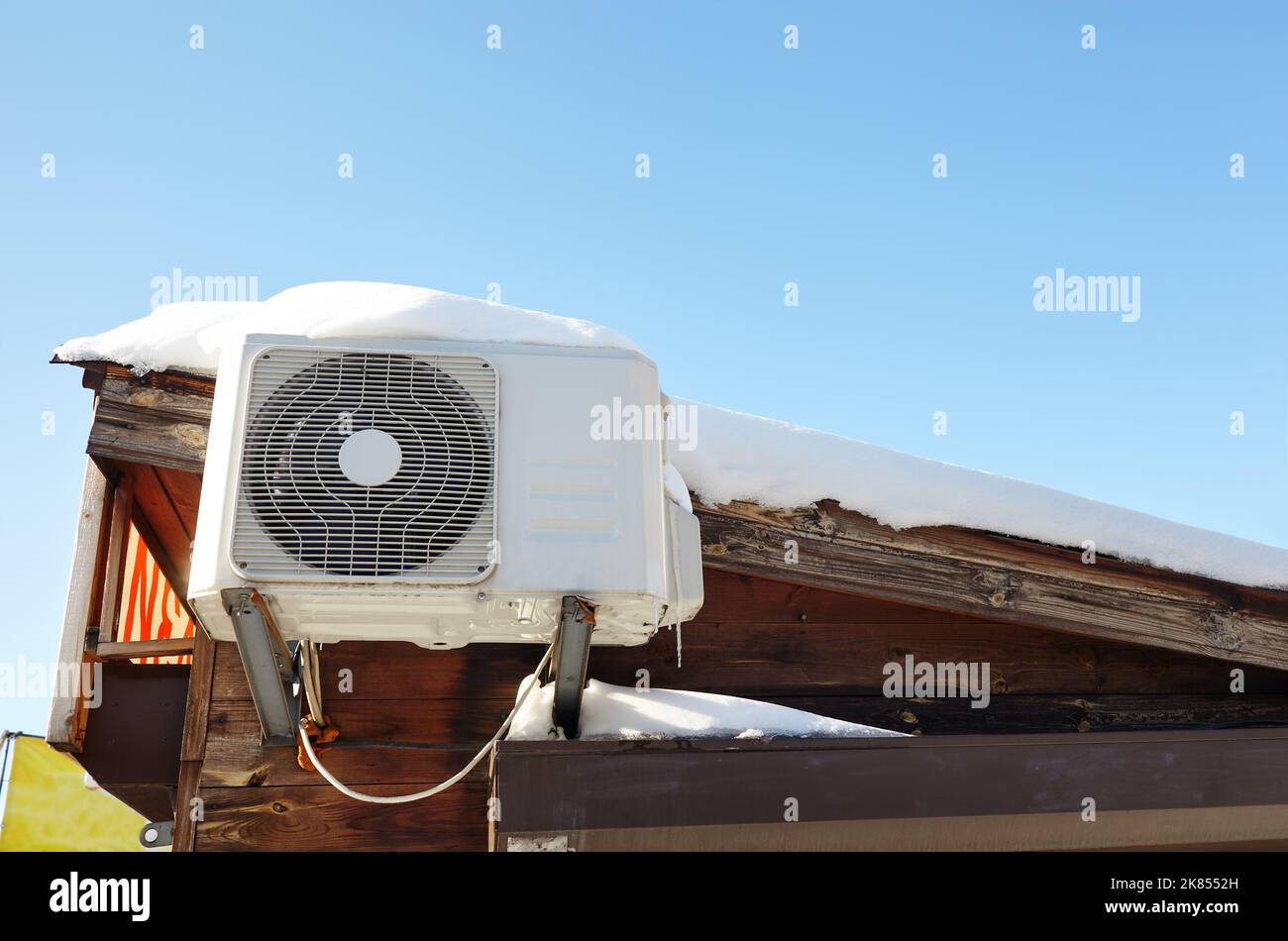 Snow covered invertor Air conditioner outdoor unit closeup on roof top ...