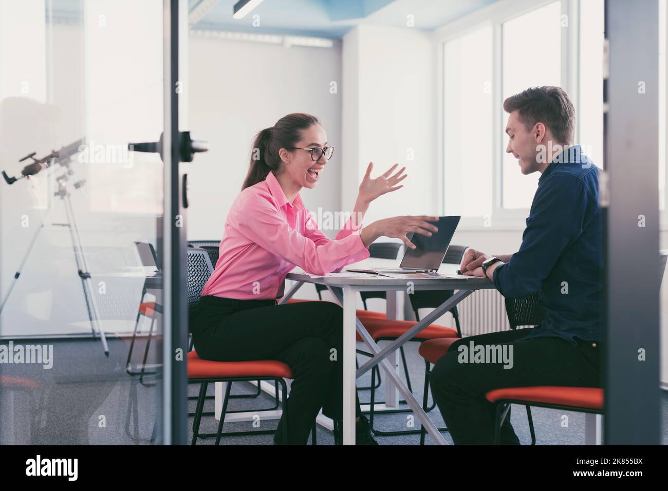 Emotional couple of young colleagues arguing in modern office. African ...