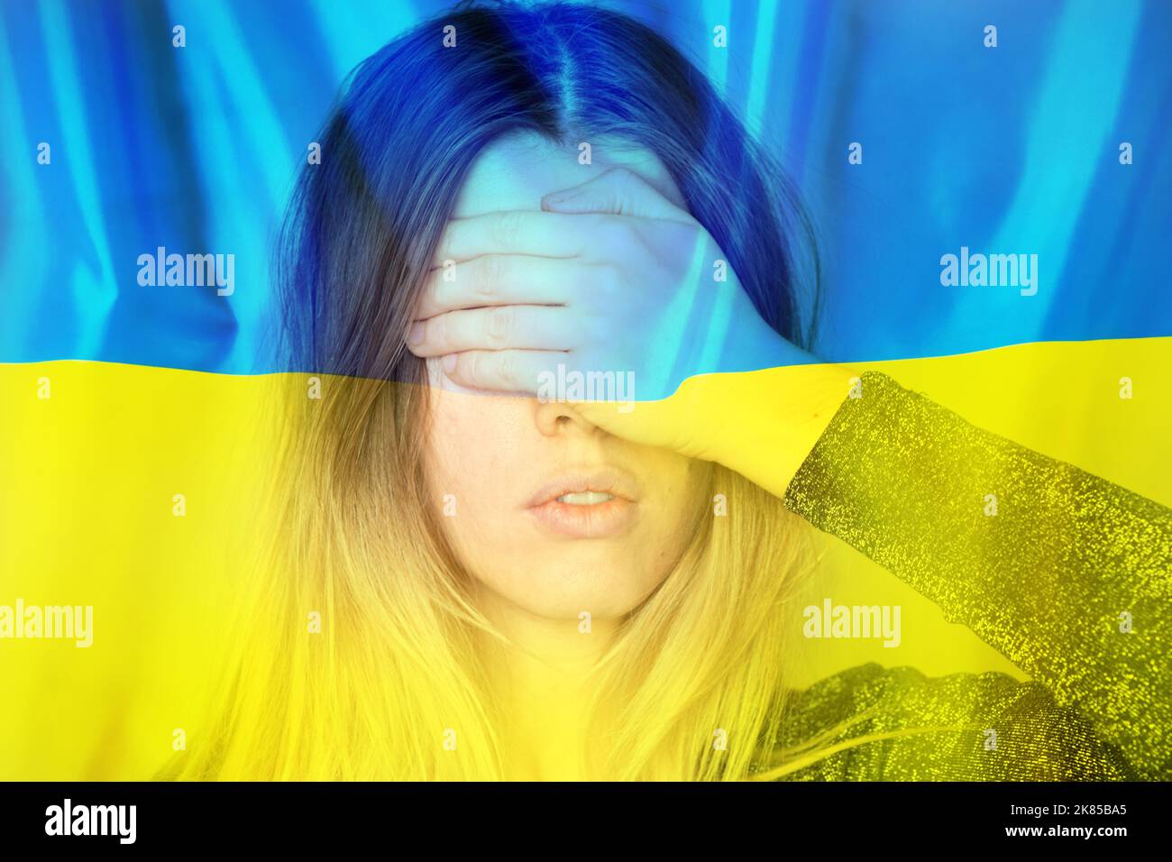 The girl closed her eyes with her hand against the background of the ...