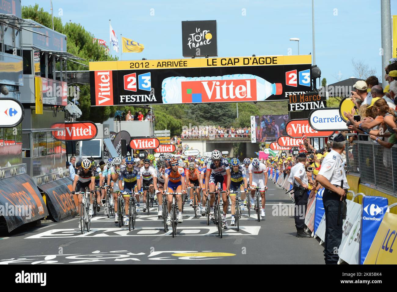 The back of the race, a group of riders cross the finish line including ...
