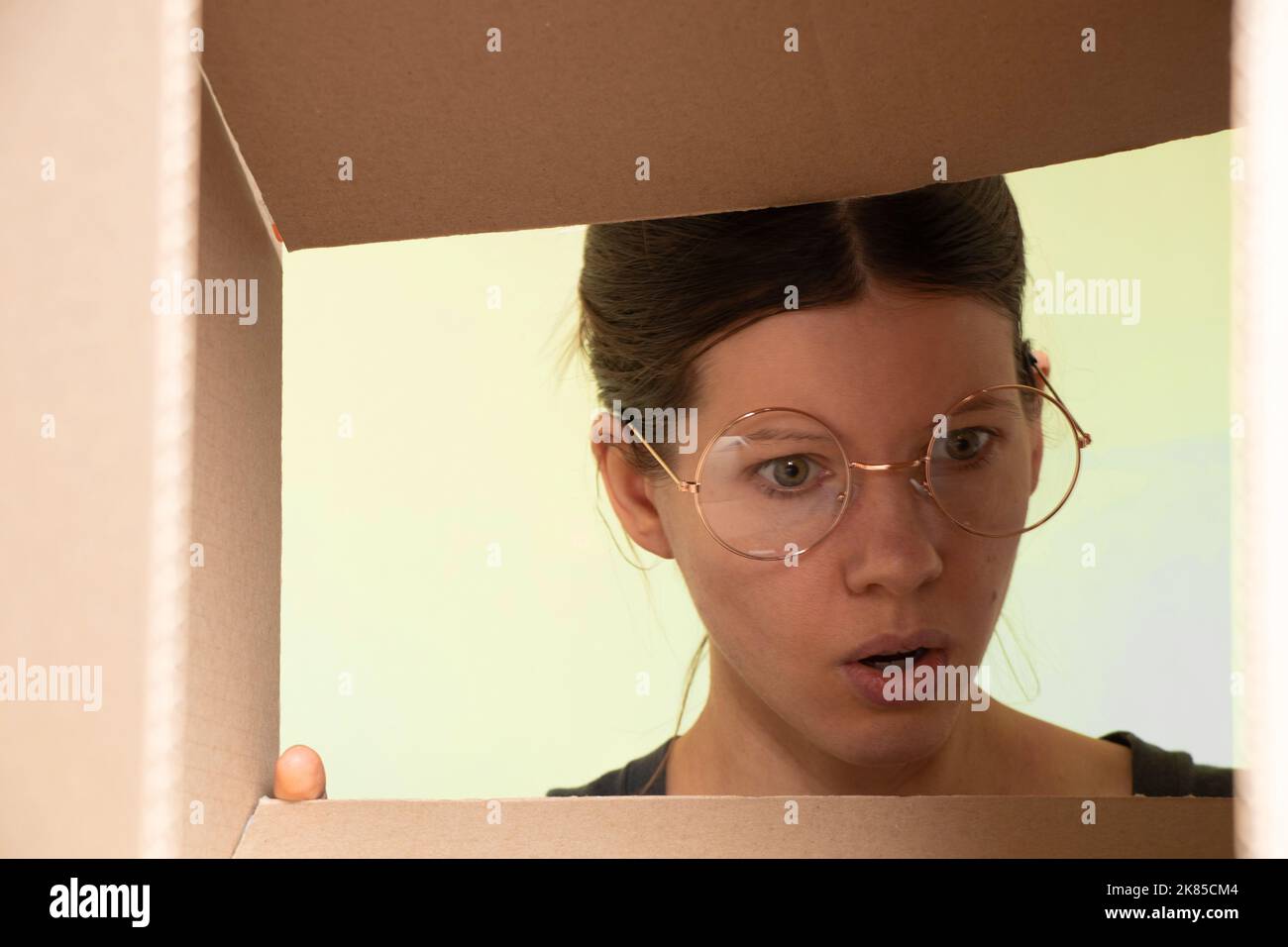 the girl's face looks into the cardboard box, receiving the parcel ...