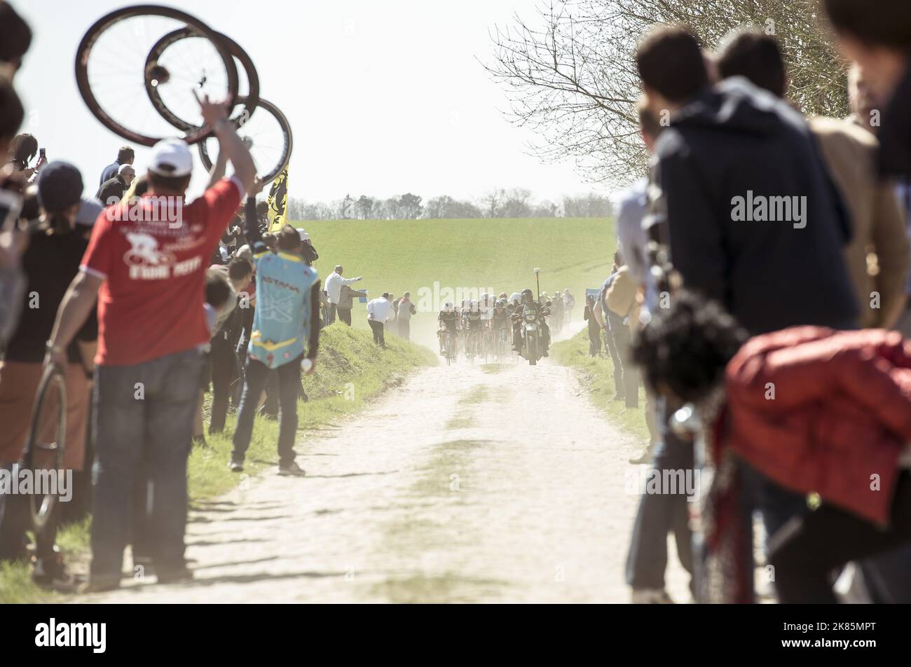 The peleton chase down the break whilst team soigneurs hold replacement ...