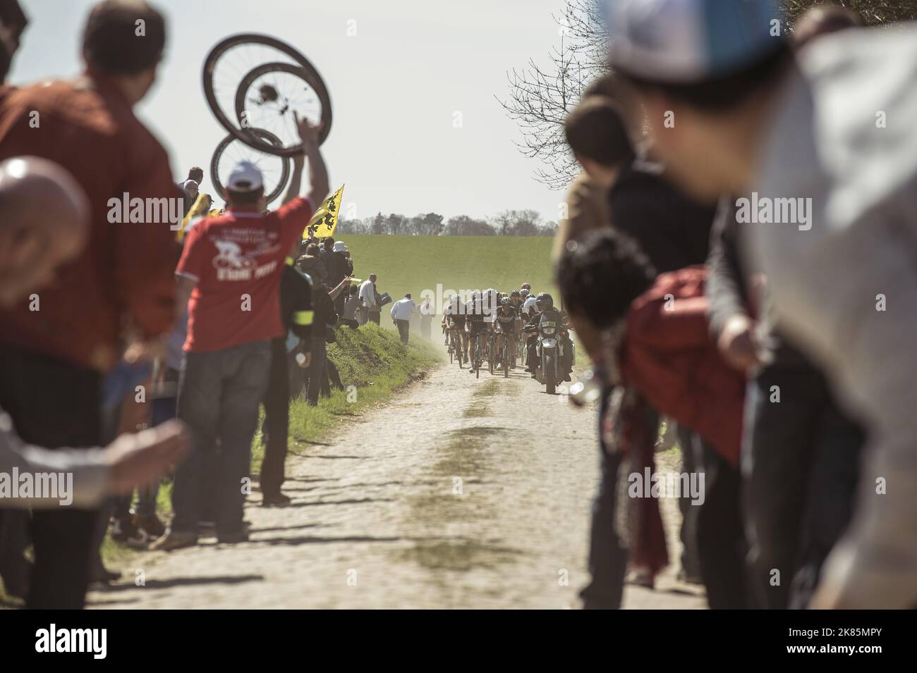 The peleton chase down the break whilst team soigneurs hold replacement ...