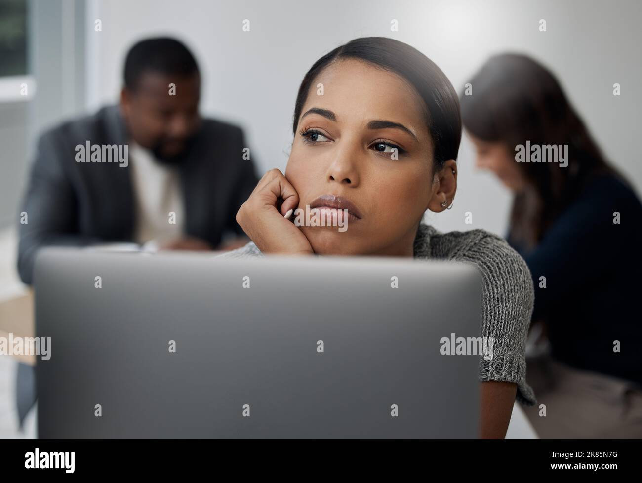 Thinking about leaving today. a young businesswoman looking bored at ...