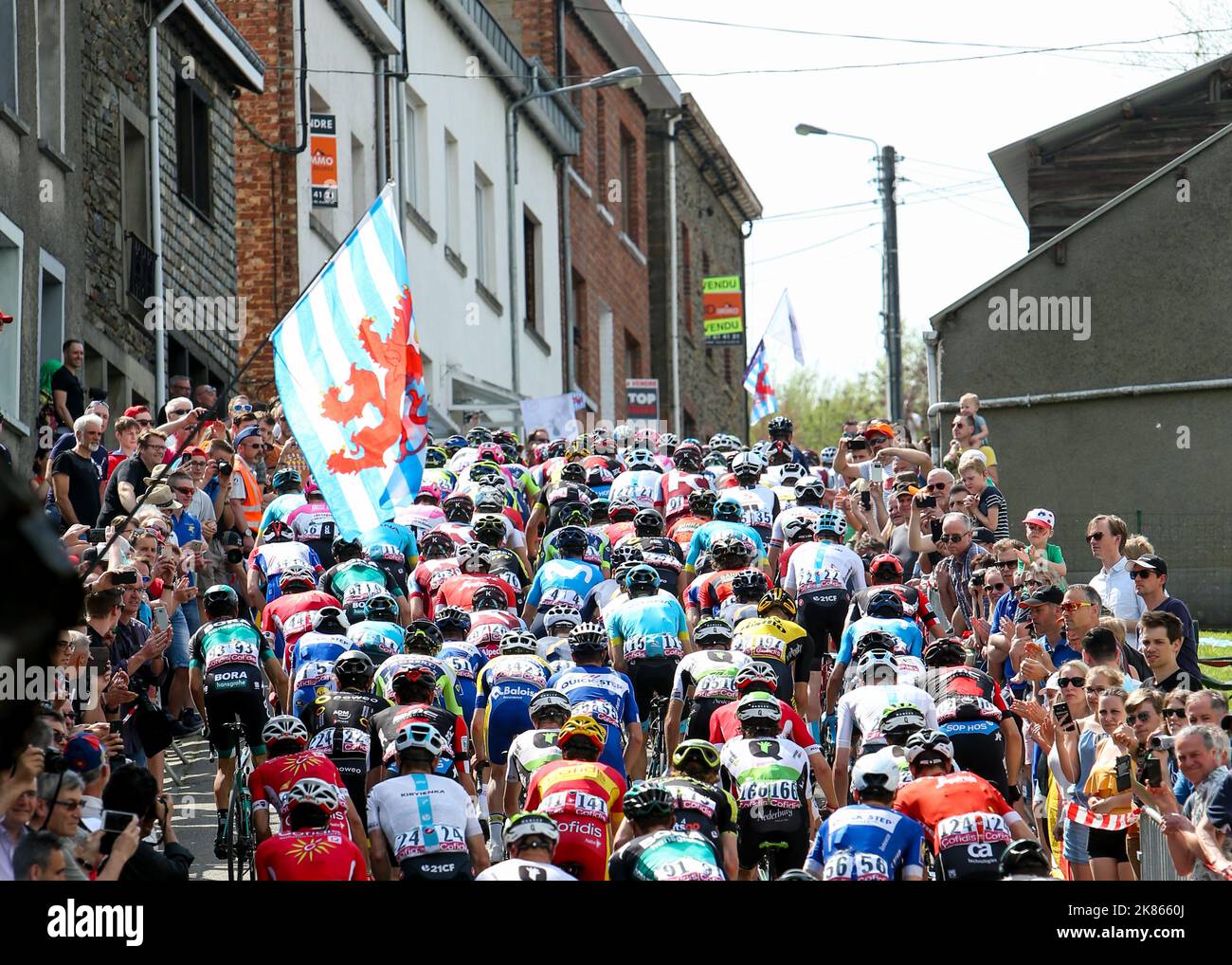 The Peloton climb through the lined streets in Houffalize on the climb ...