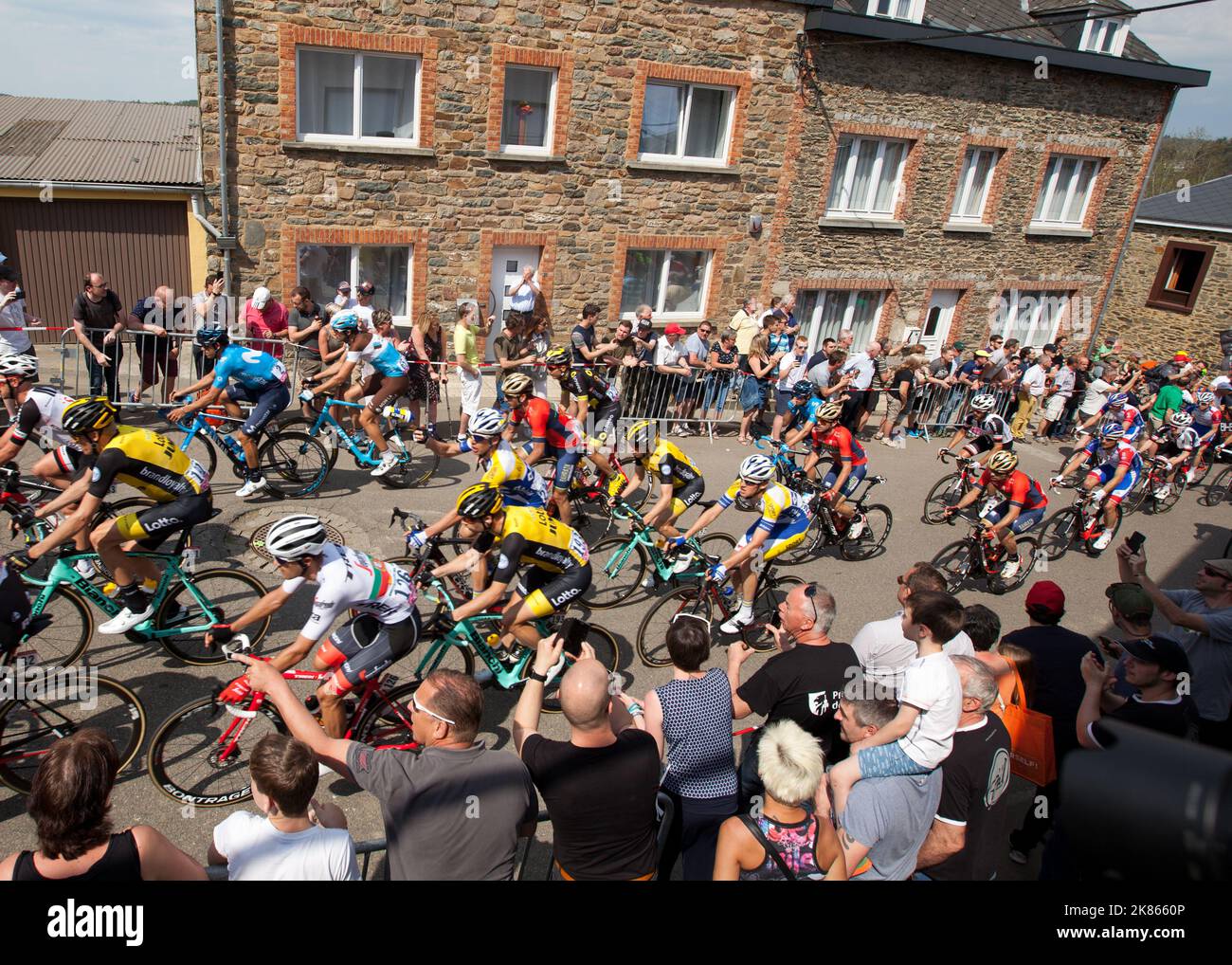 The Peloton climb through the lined streets in Houffalize on the climb ...