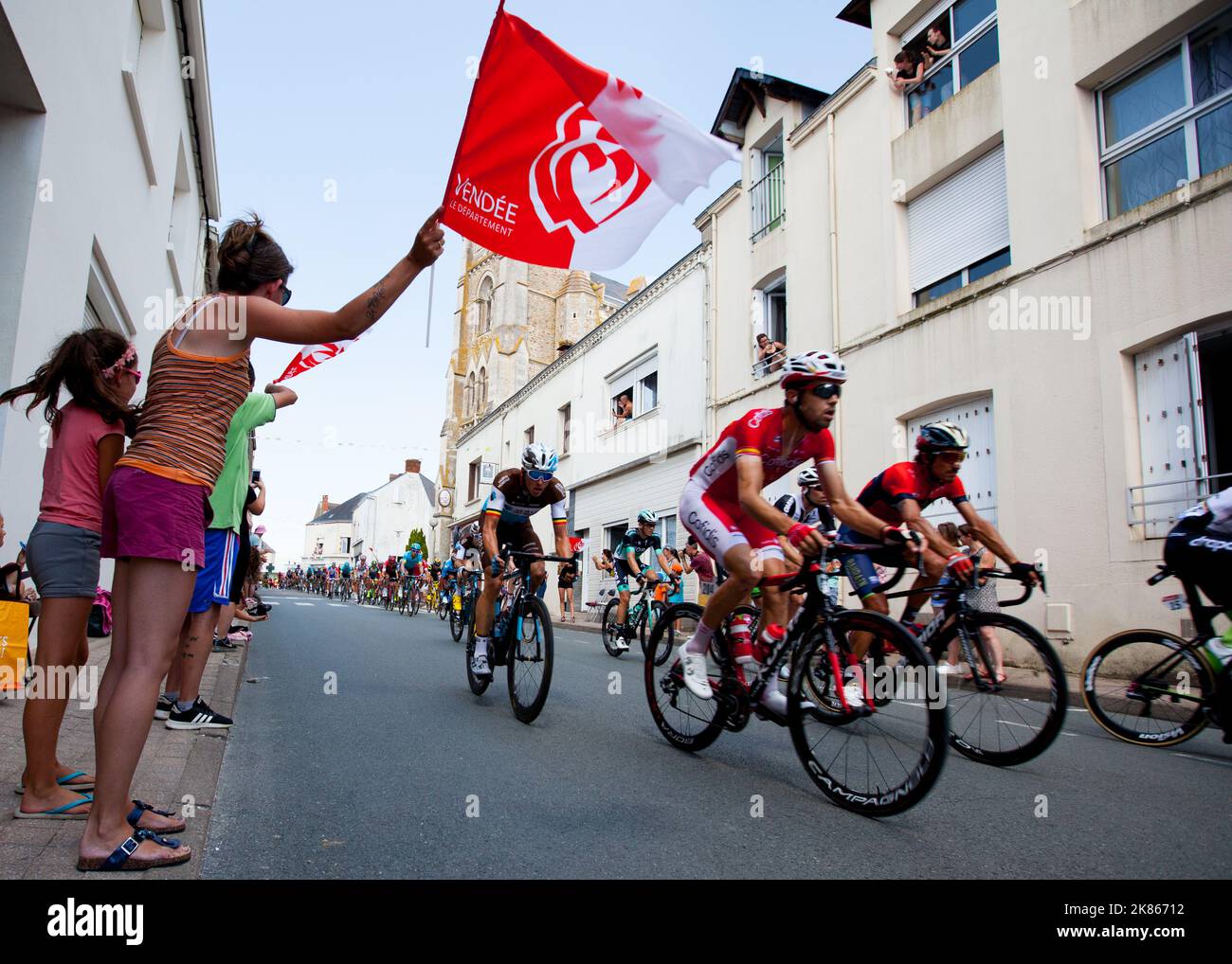 Local fans waving Vendee flags as the riders pass through La Chapelle ...