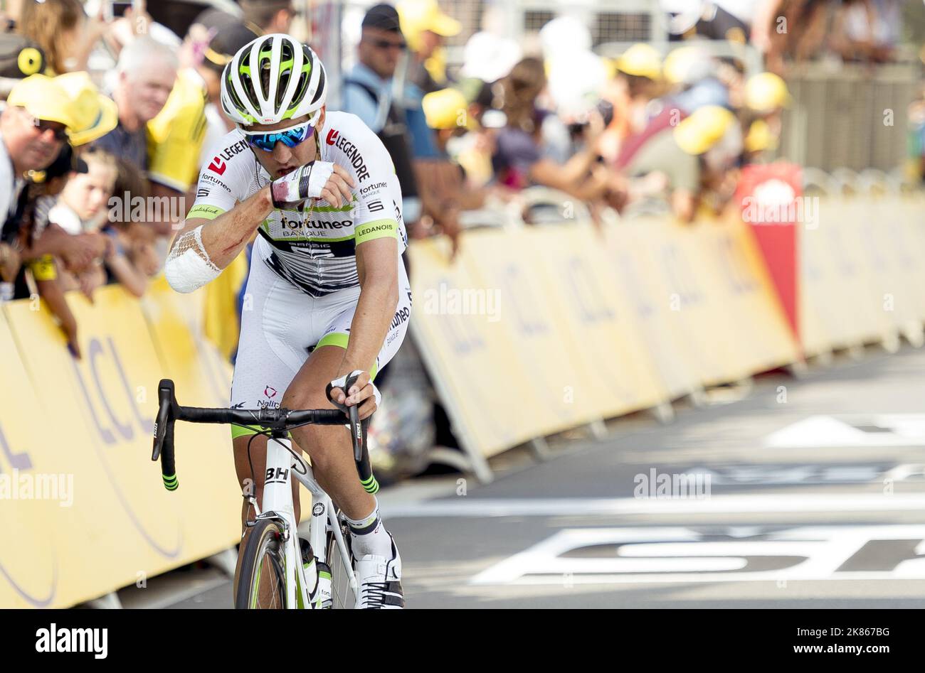 Team Fortuneo rider nurses his wounds as he crosses the finish line ...