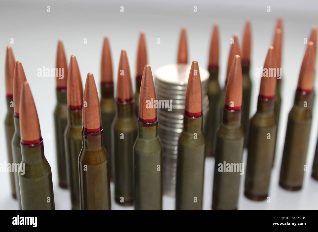 Rows of gun bullets with blurred coins column inside a rows stock photo ...