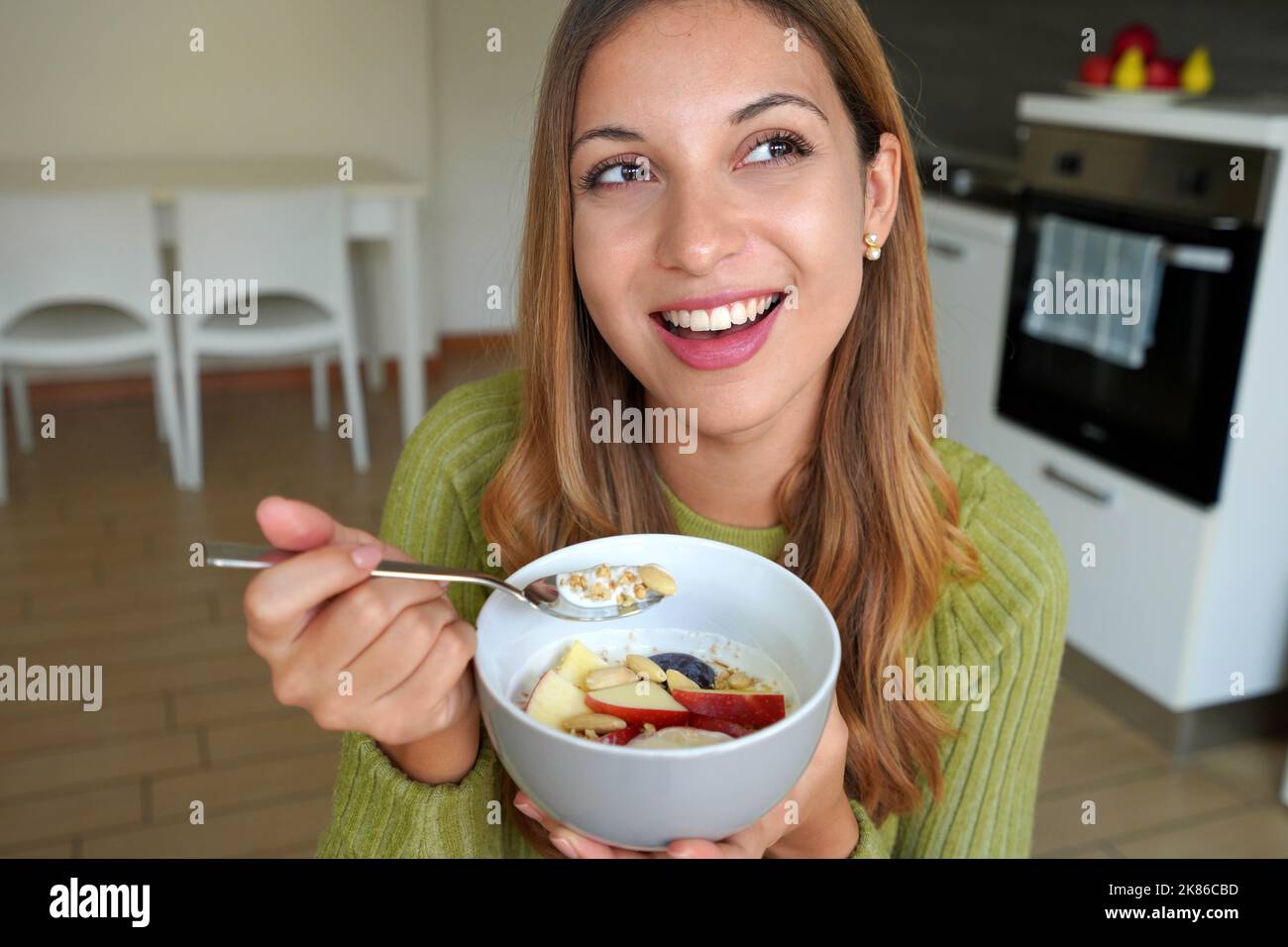 Beautiful woman eating muesli granola oatmeal with fruits and yogurt ...