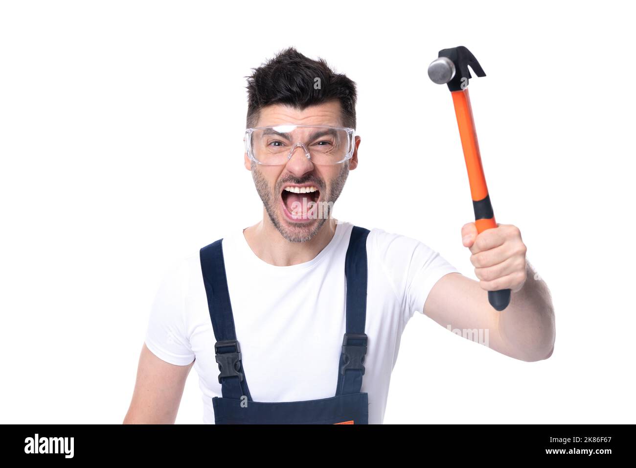 angry repairman using hammer tool. repairman with hammer in studio ...