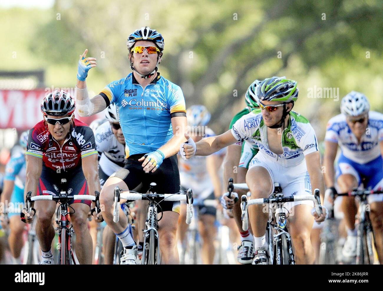 Mark Cavendish celebrates on the podium the finish line as Robbie ...