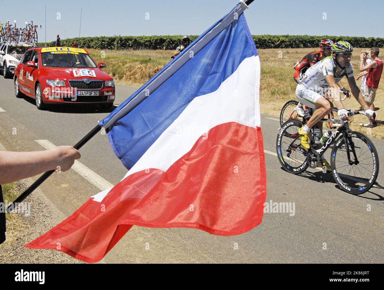 A Tour De France fan waves the French national flag during stage 13 of ...