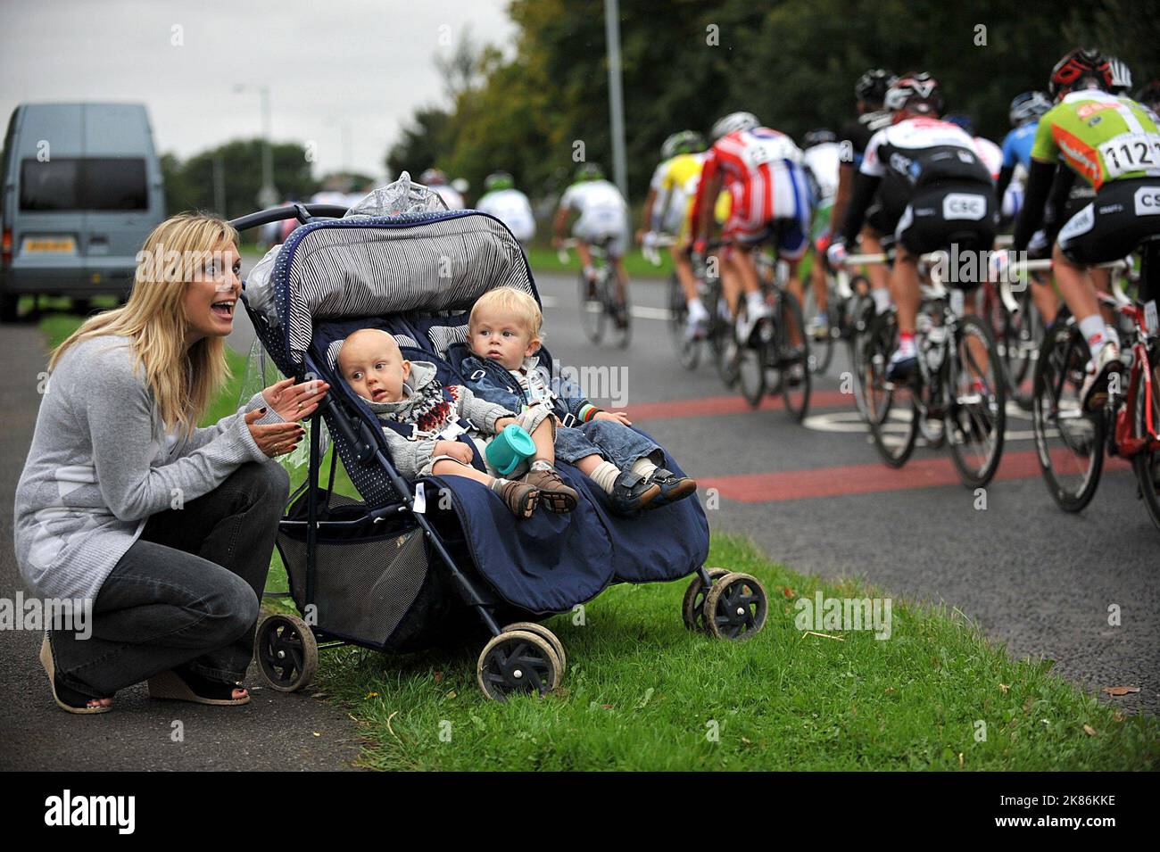 A mohter and her two children watch as the peloton passes during Stage ...