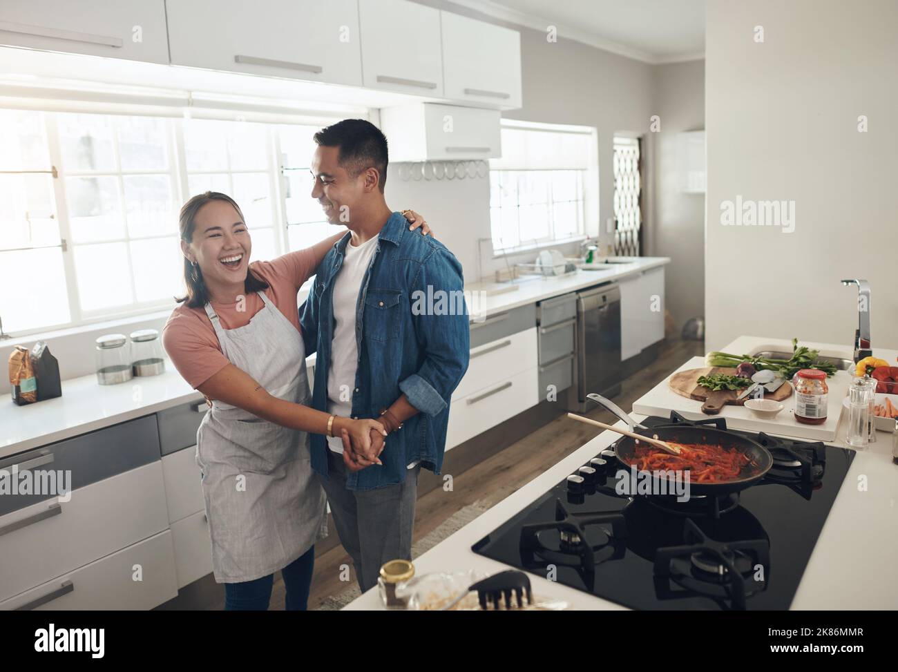 Cooking with love and flare. a young couple dancing while cooking ...