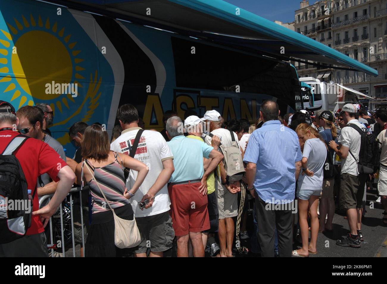 A crowd gather around the Astana team bus before the start of the third ...