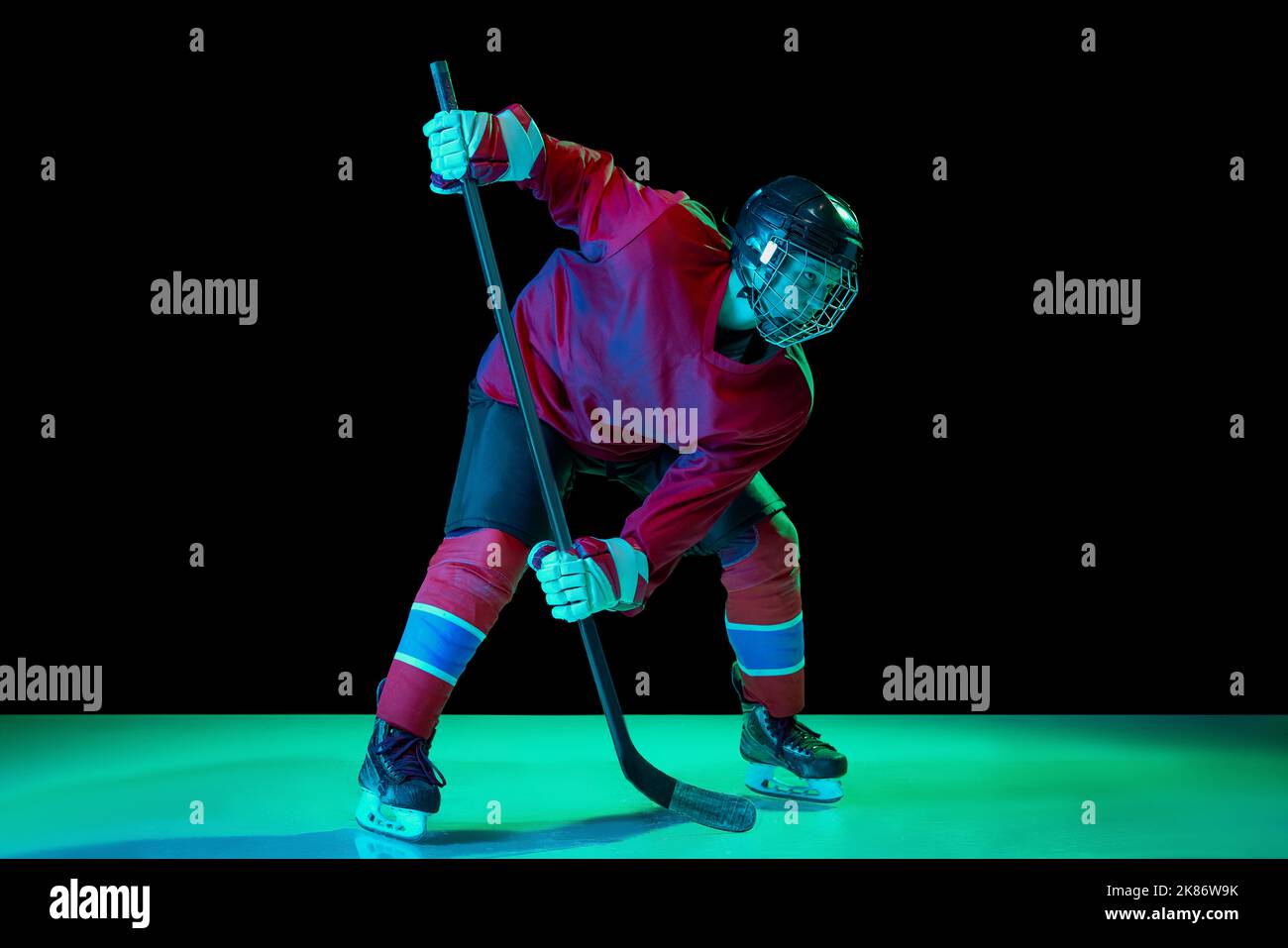 Junior ice hockey player in sports uniform and protective equipment in ...