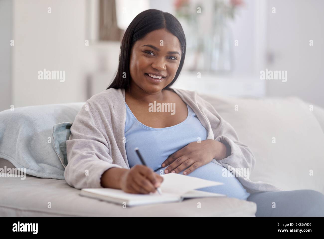 I jot down every kick and every other feeling. a pregnant woman writing ...