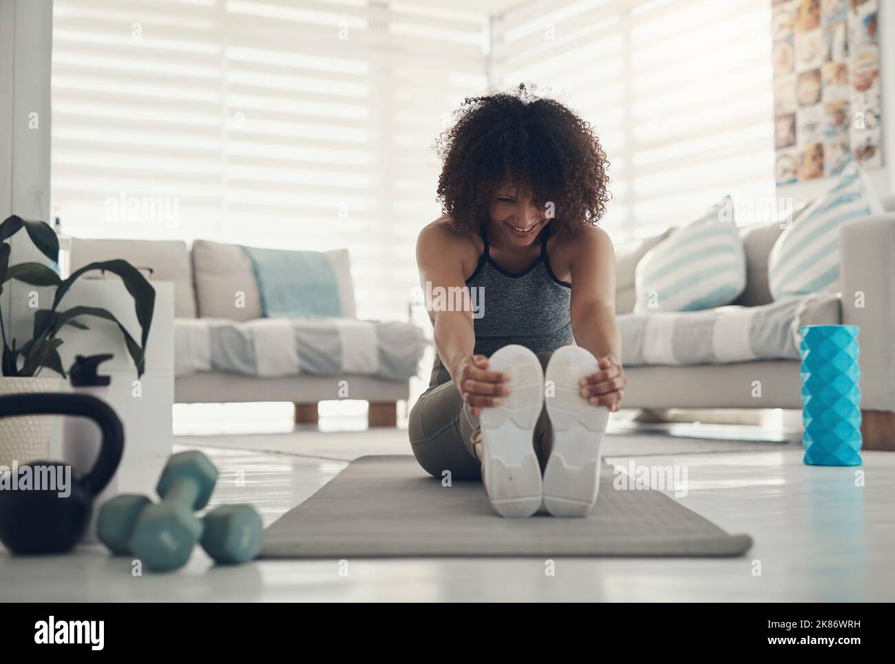 Workouts boost my mood. an attractive young woman sitting alone in her ...