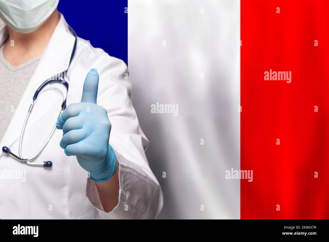 French doctor's hand showing thumb up positive gesture on flag of ...