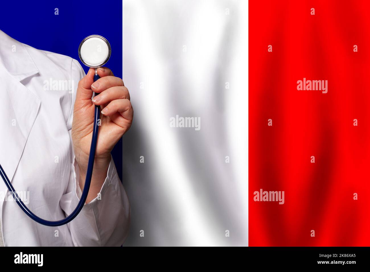 French medical worker's hand with stethoscope on flag of France ...