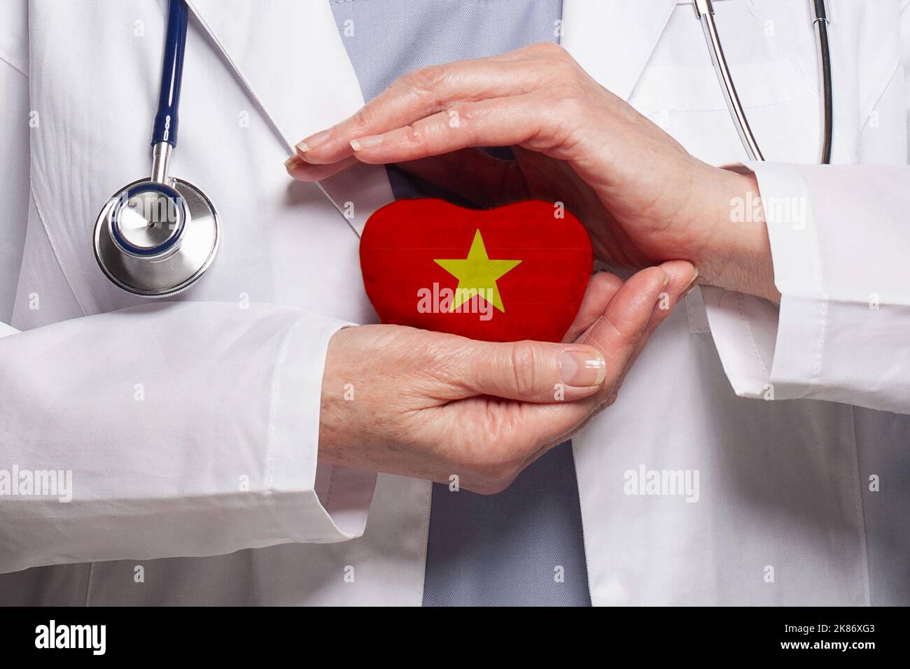 Vietnamese doctor holding heart with flag of Vietnam background ...