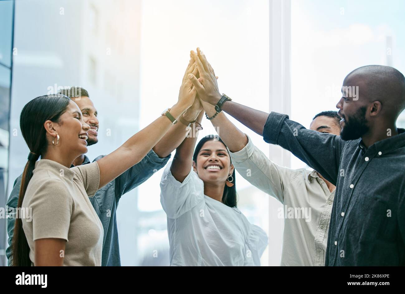 Teamwork has made the dream work. a group of coworkers high fiving each ...