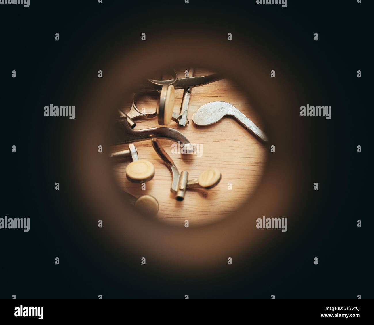 Various old clarinet keys and pads are seen through the aperture of a ...