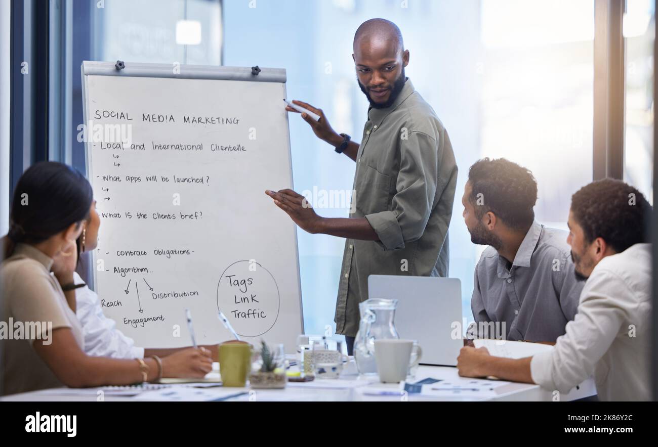 Putting together all their ideas. a young businessman presenting a ...