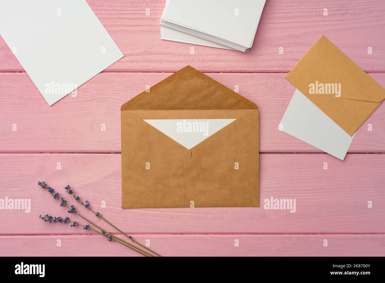 Beige envelope with blank letter on pink wooden desk Stock Photo - Alamy