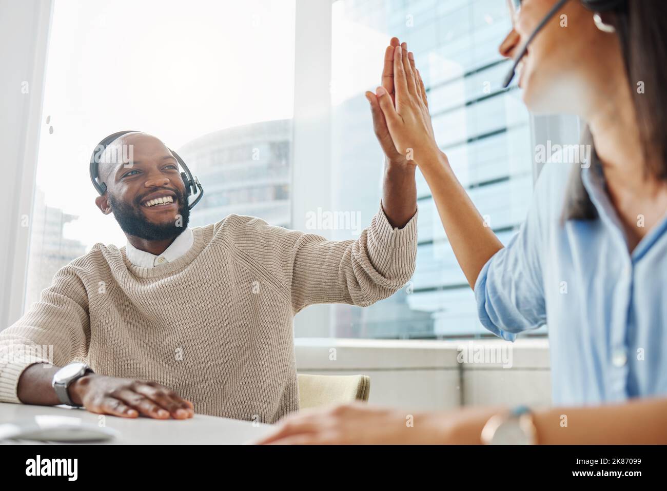 Teamwork for the win. two young call centre agents sitting together in ...