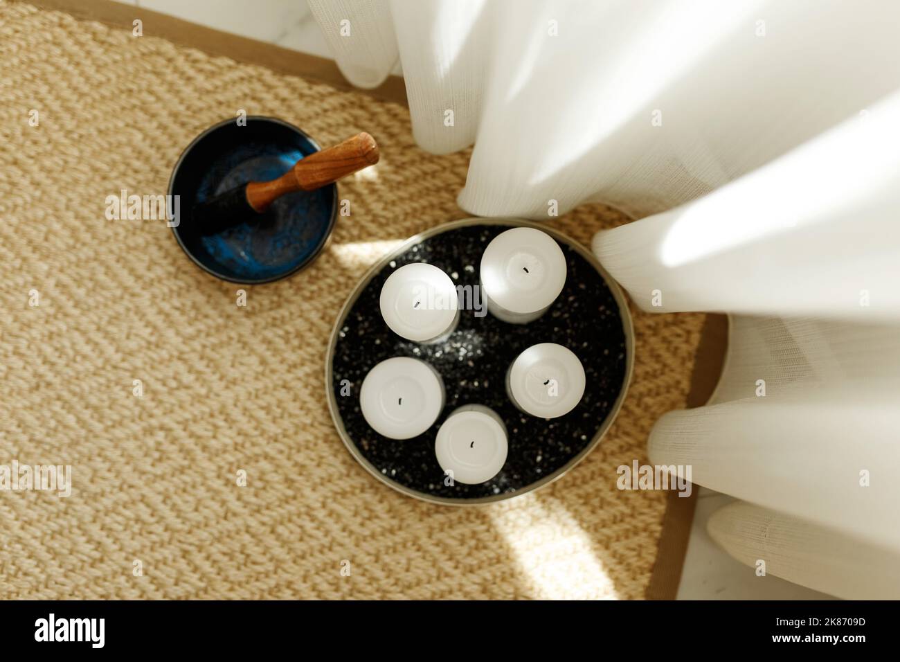 Beautiful burning candle on floor in room. Natural floor cover, window ...