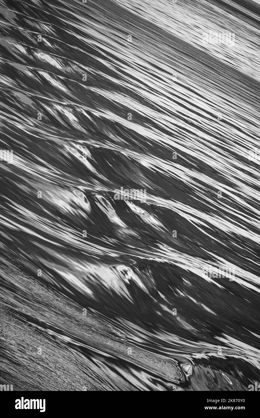A vertical grayscale shot of waves in the sea Stock Photo - Alamy