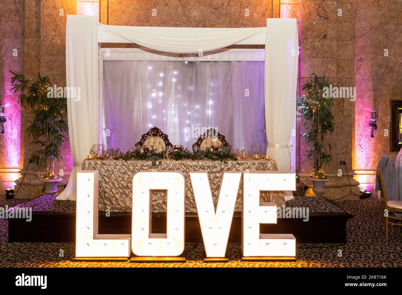 A beautiful interior design of a Wedding Dais with glowing LOVE text ...