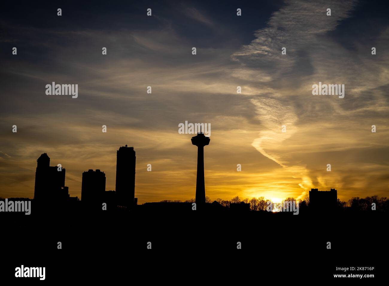 A beautiful view of a golden sunset sky over silhouette towers and ...
