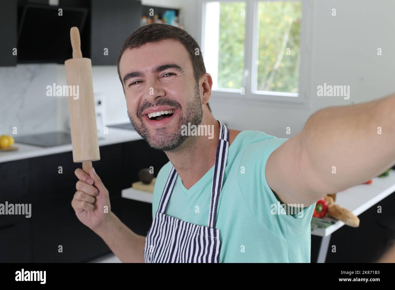 Man taking selfie with rolling pin in the kitchen Stock Photo - Alamy