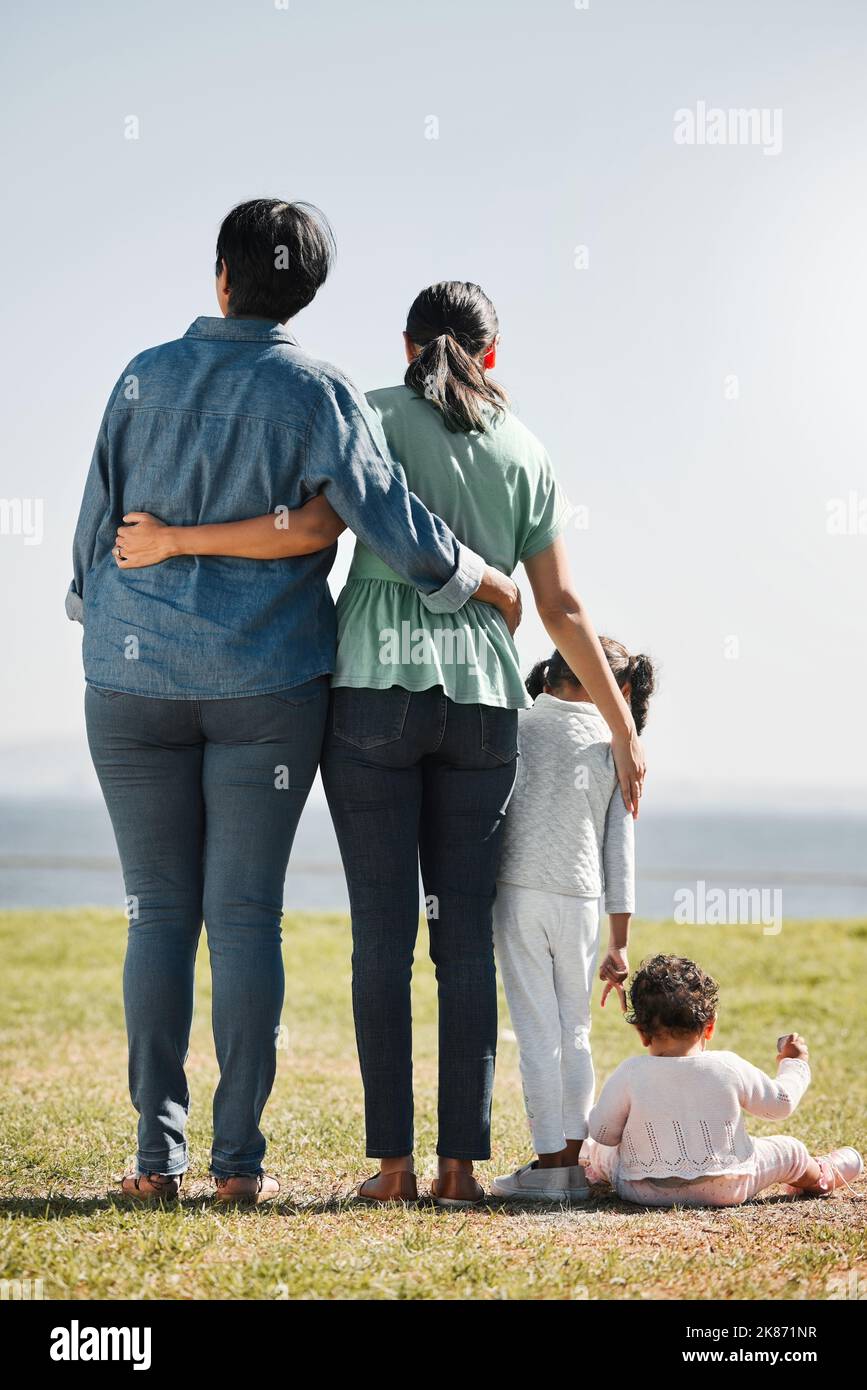 Park, nature and back view of family on grass outdoors with relatives ...