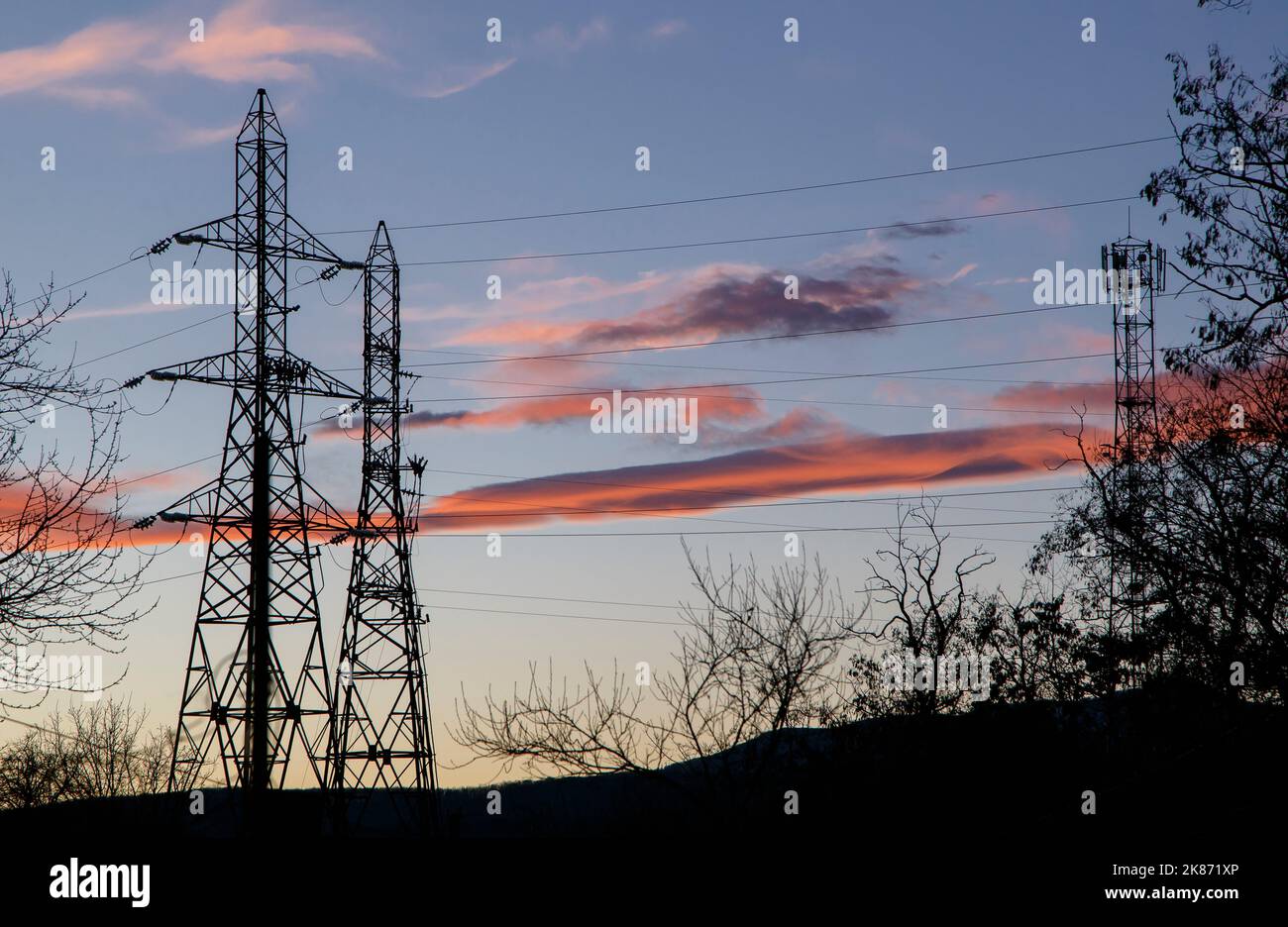 Electricity pylons and lines at sunset Stock Photo - Alamy