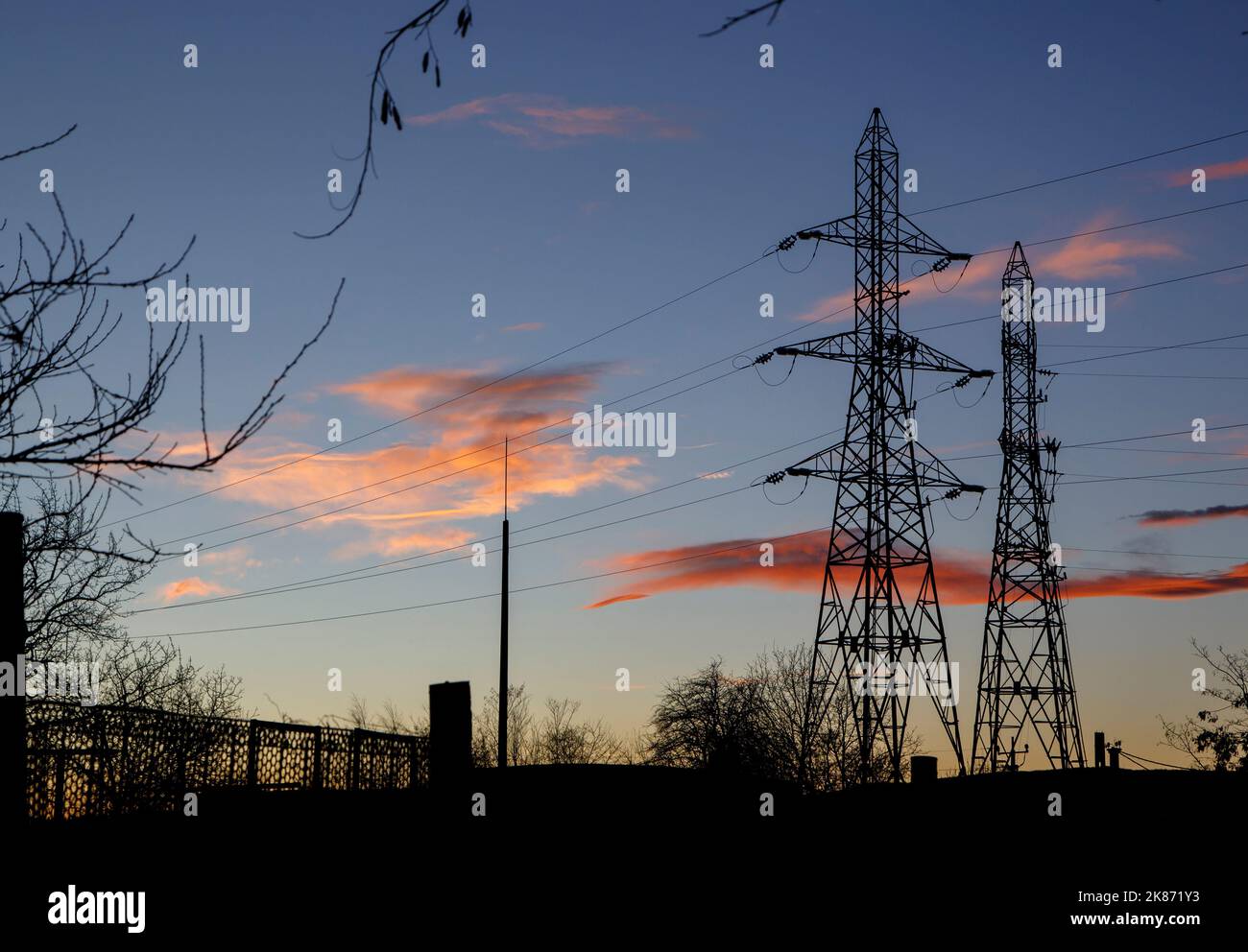 Electricity pylons and lines at sunset Stock Photo - Alamy