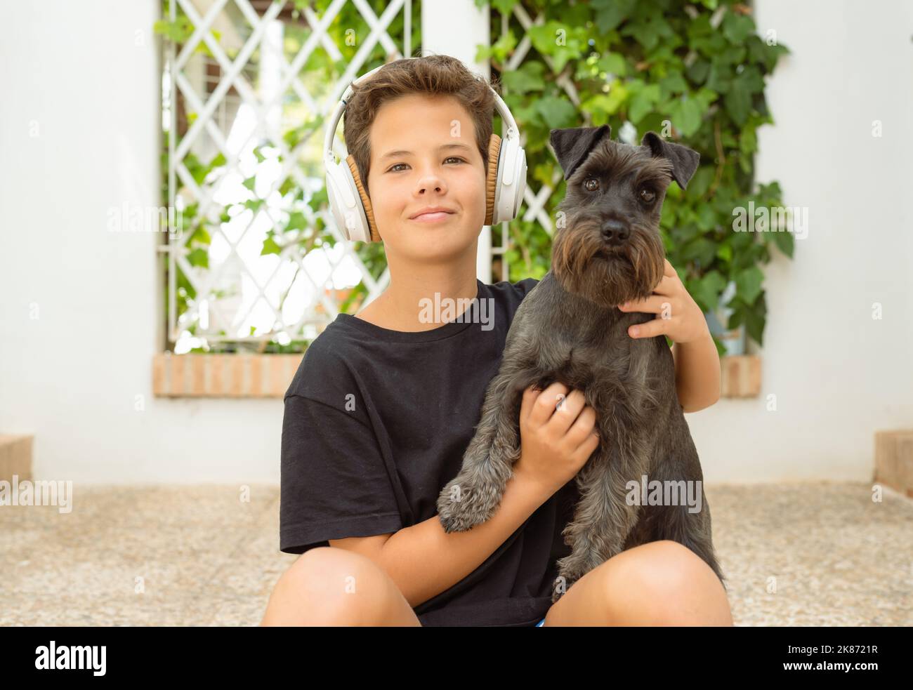 Little cute boy is sitting with his dog. They enjoy together on a ...