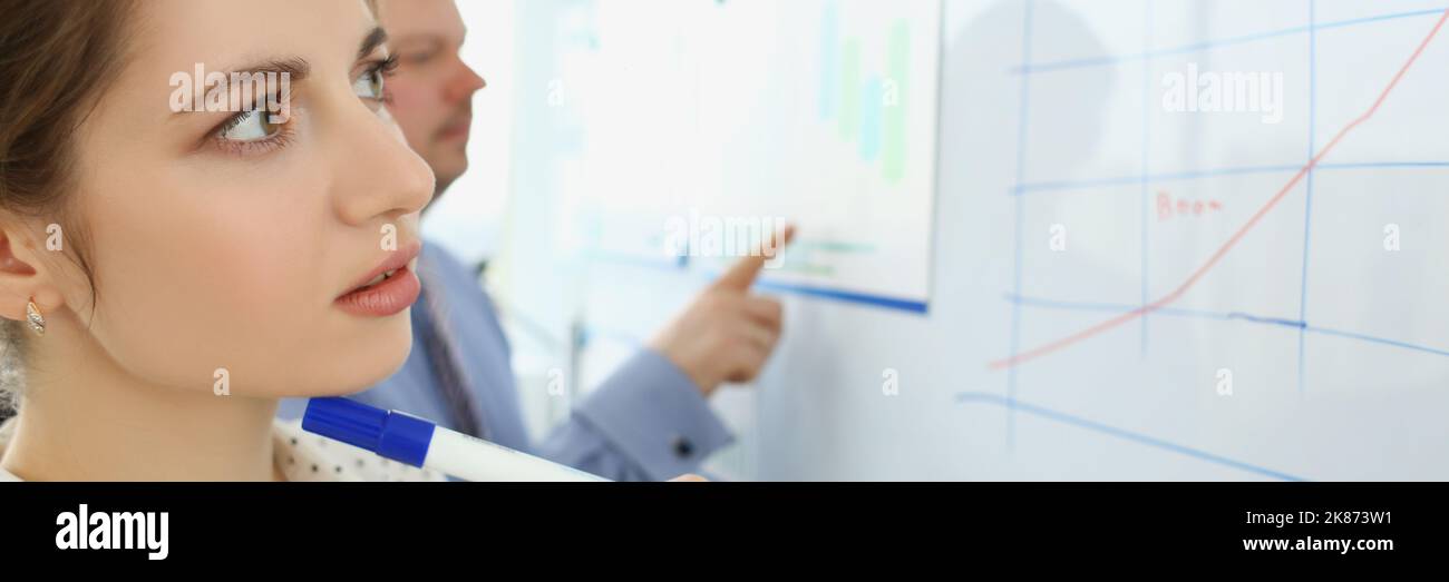 Smart pensive woman draw graphics and charts on white board Stock Photo ...