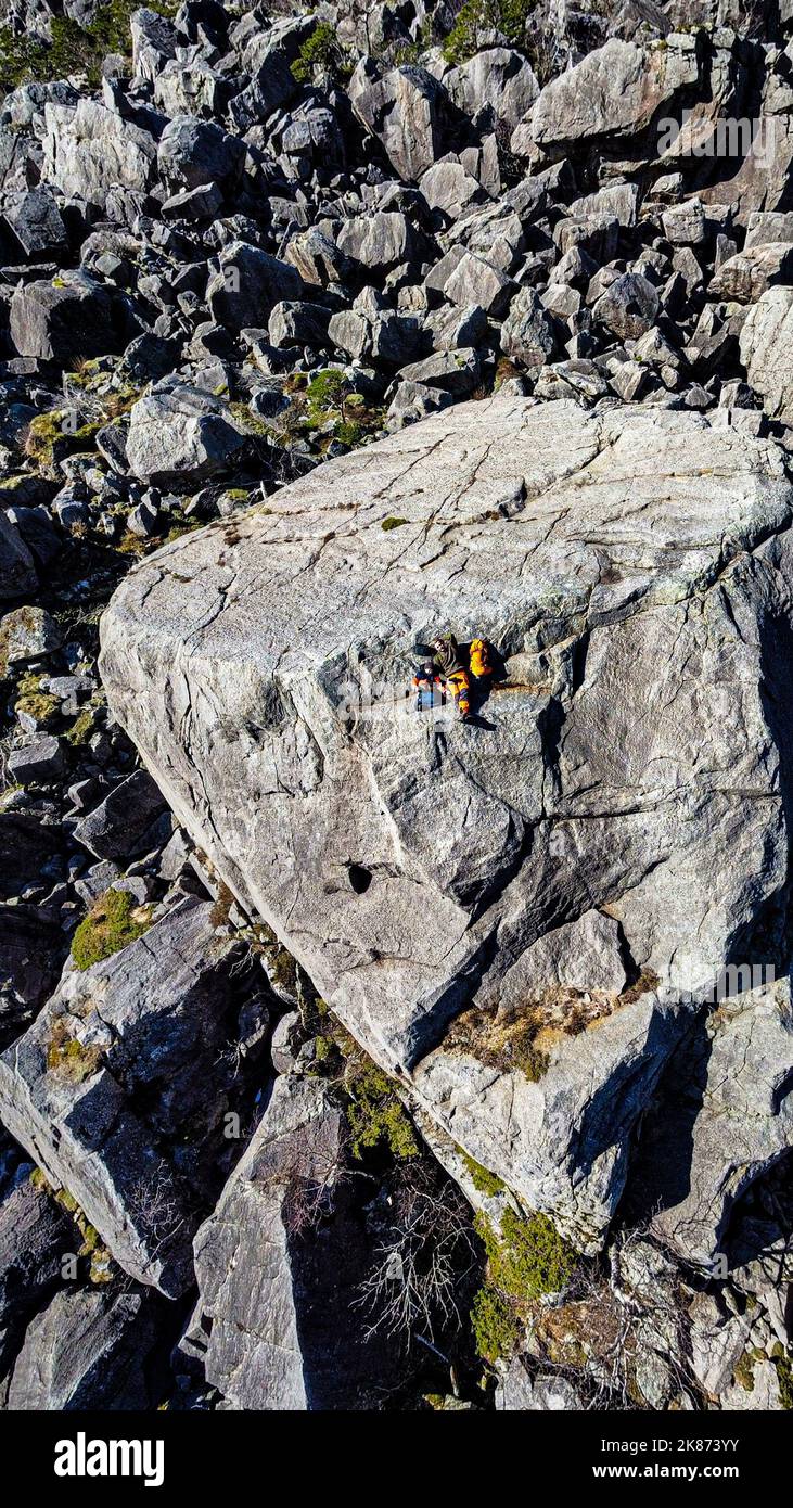 An aerial view of boys chilling on big rock formations in Norway Stock ...