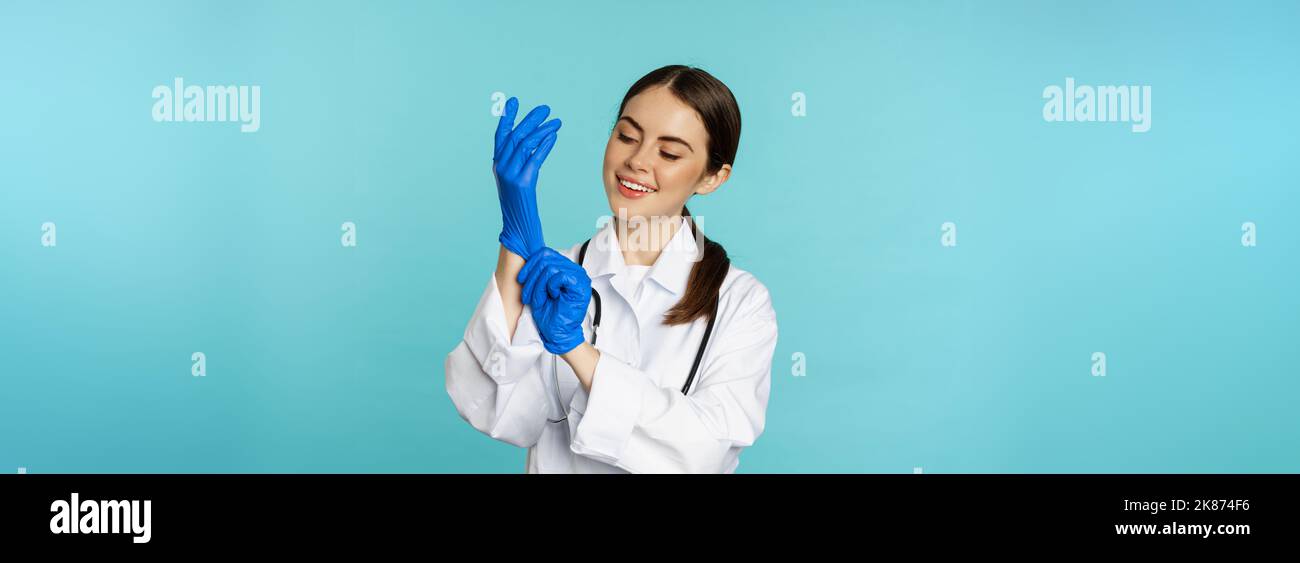 Smiling young woman, medical worker wearing gloves for patient checkup ...