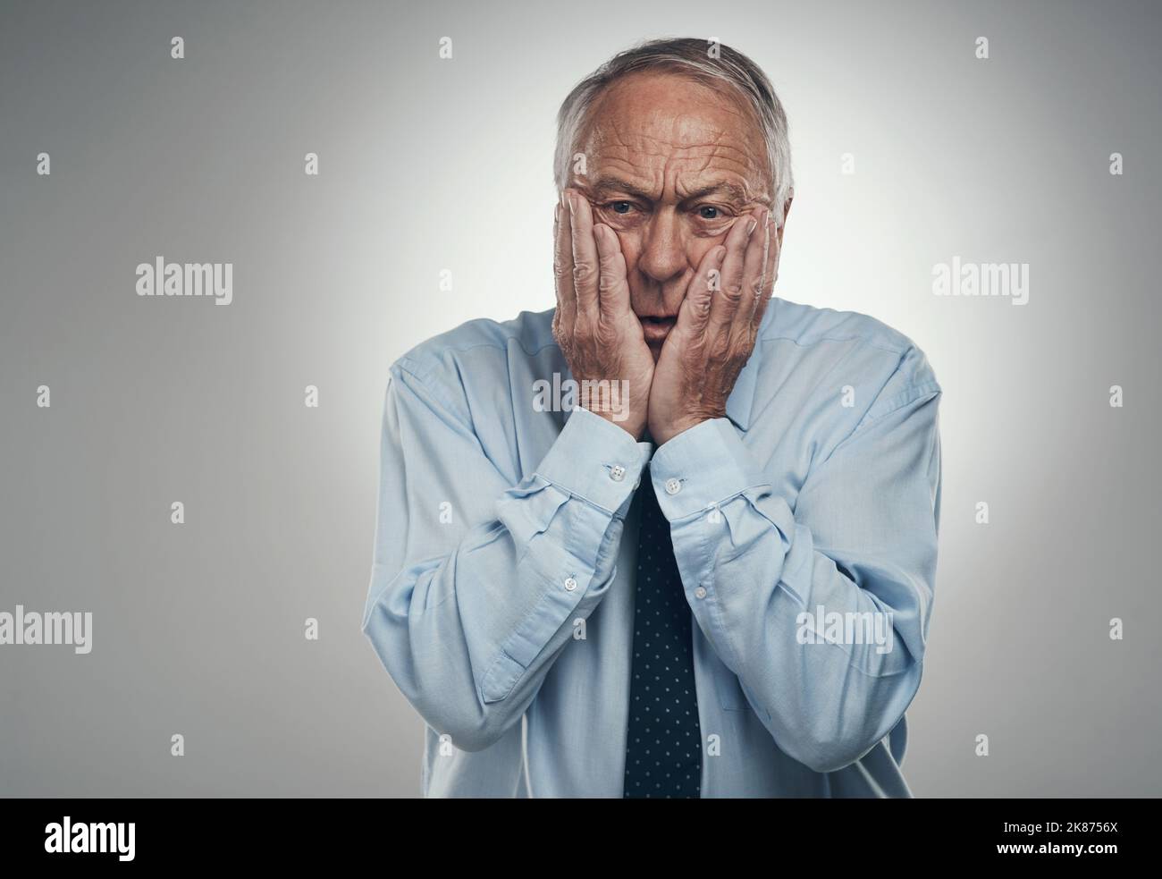 This doesnt look good. a senior businessman standing against a grey ...