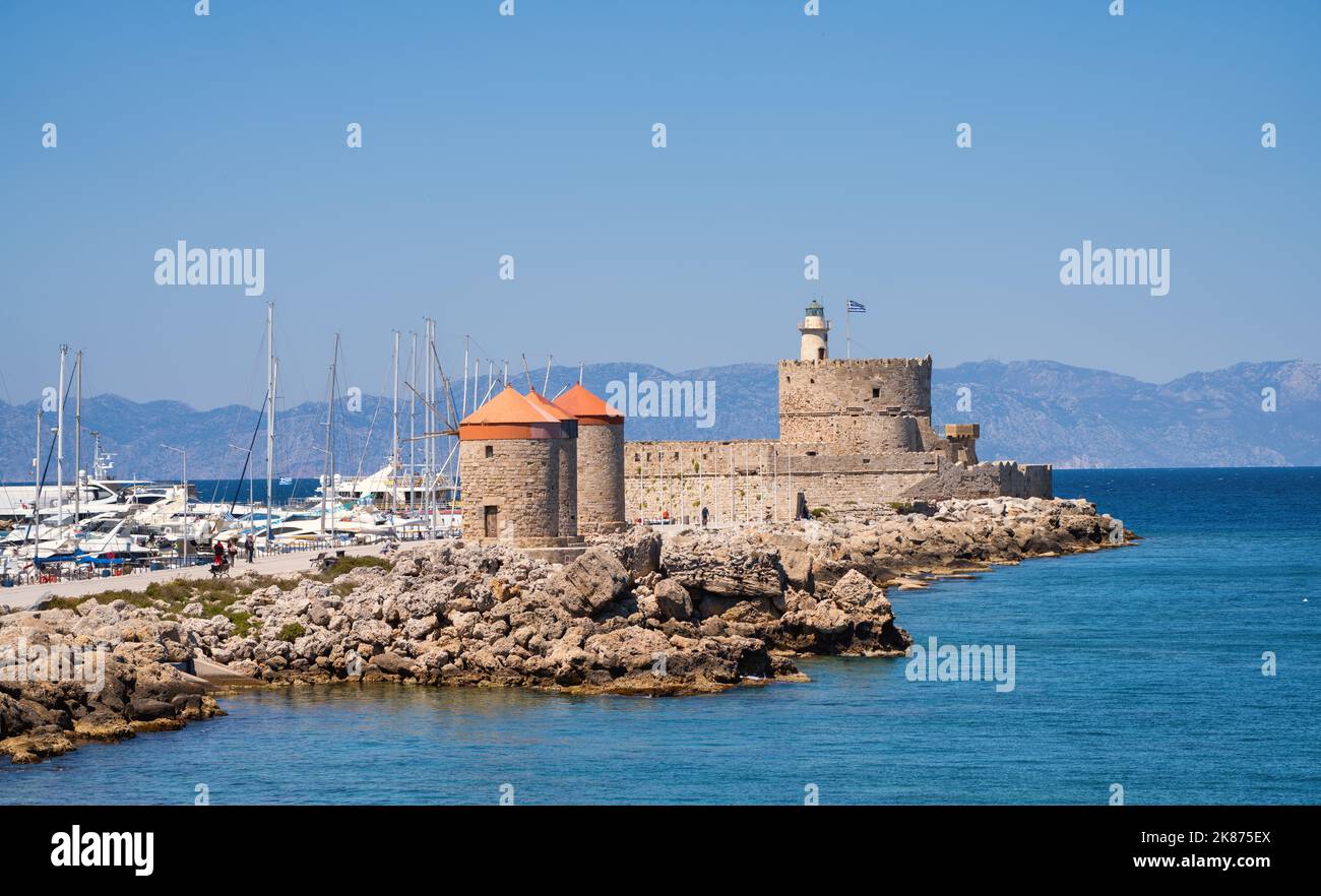 The Saint Nicholas Fortress and windmills at Mandraki Harbor, Rhodes ...