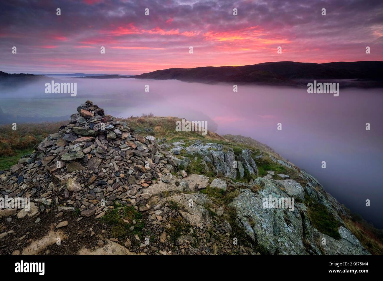 Summit Cairn on Yew Crag above misty Ullswater at sunrise, Gowbarrow ...