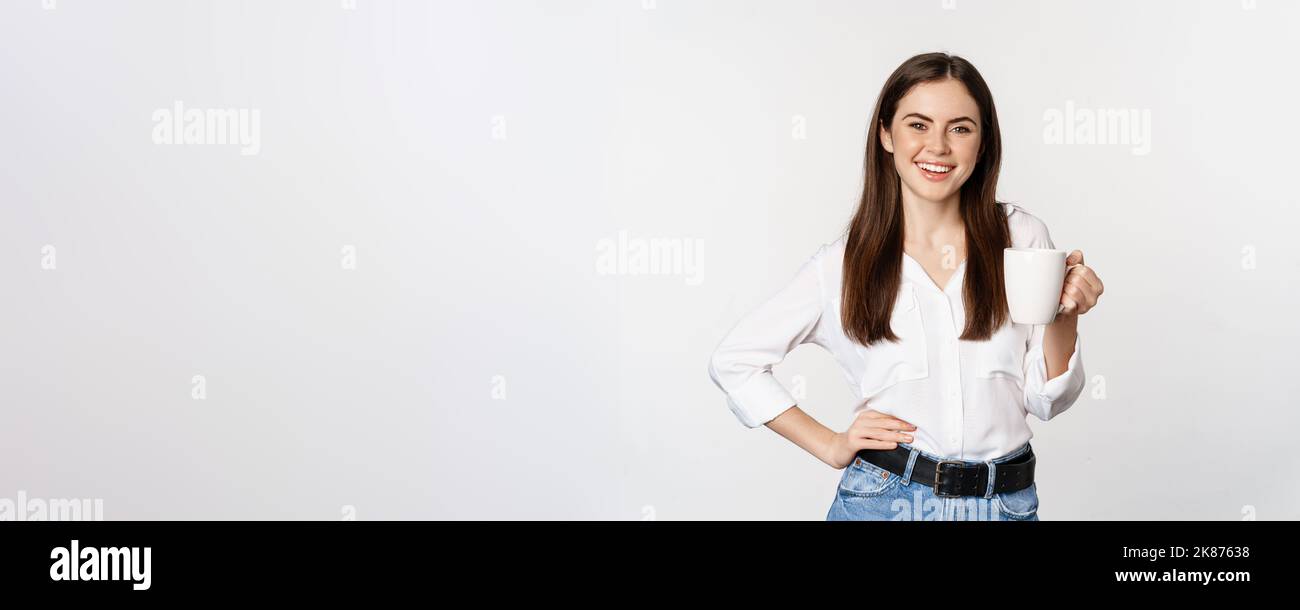 Young moder business woman, office lady holding mug with coffee tea and ...